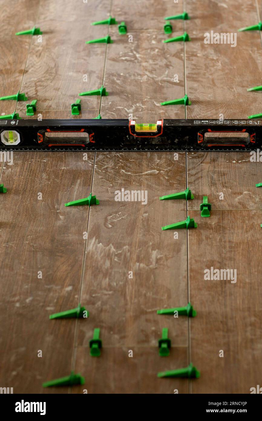 Tile levelling system, four plastic green clips with wedges. Close-up ...