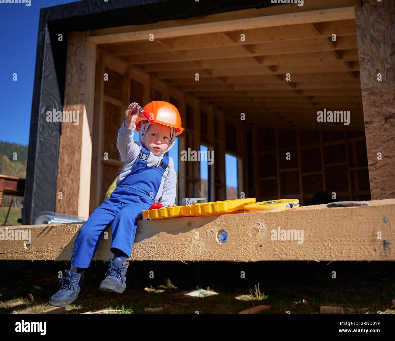 Boy toddler playing as builder on construction site. Child carpenter in ...