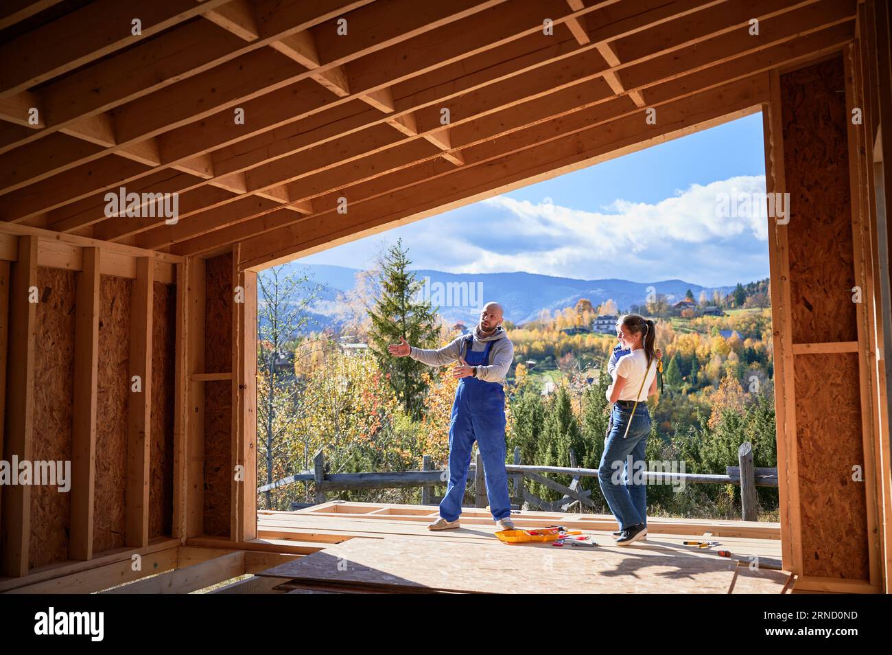 Father, mother and son building wooden frame house. Male designer in ...