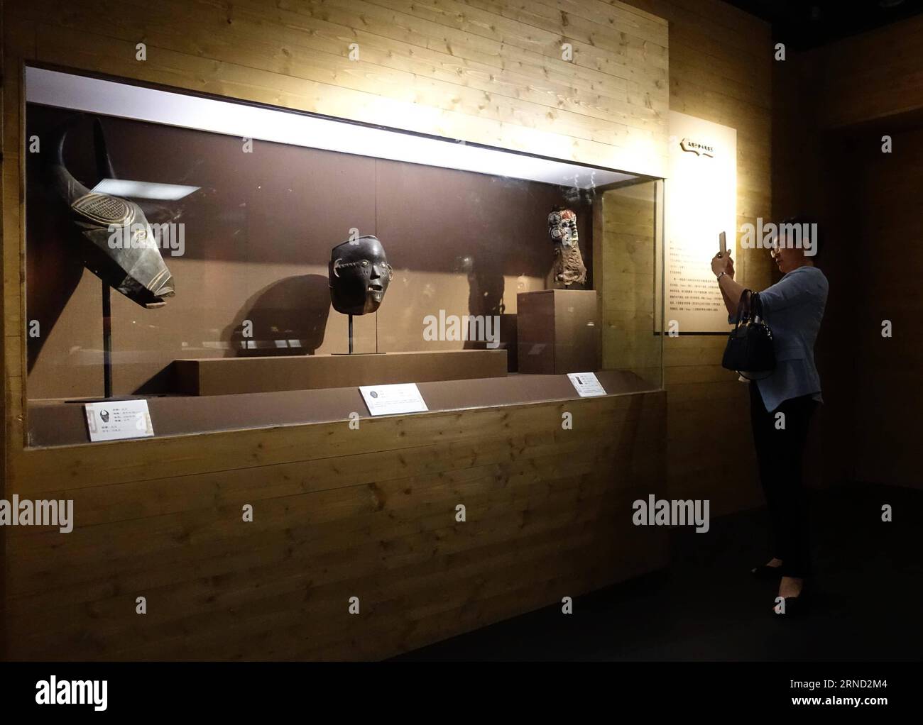 A visitor takes photos during the Face of God -- The Rare Masks from ...