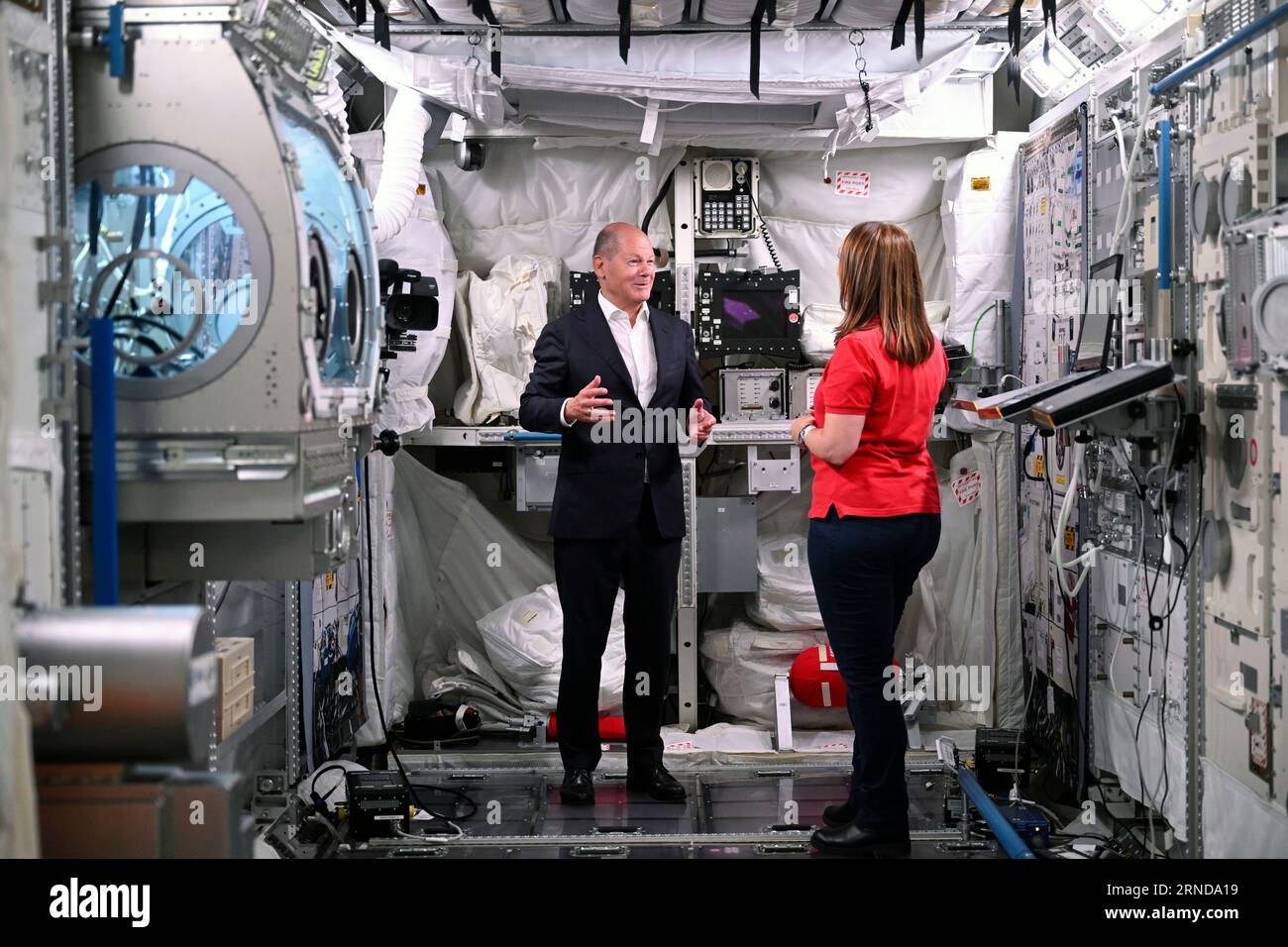 German Chancellor Olaf Scholz, left, speaks inside a model of the ...