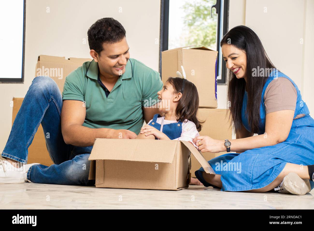 Happy young indian family with kid having fun in new home. Playing with boxes, Real estate ...