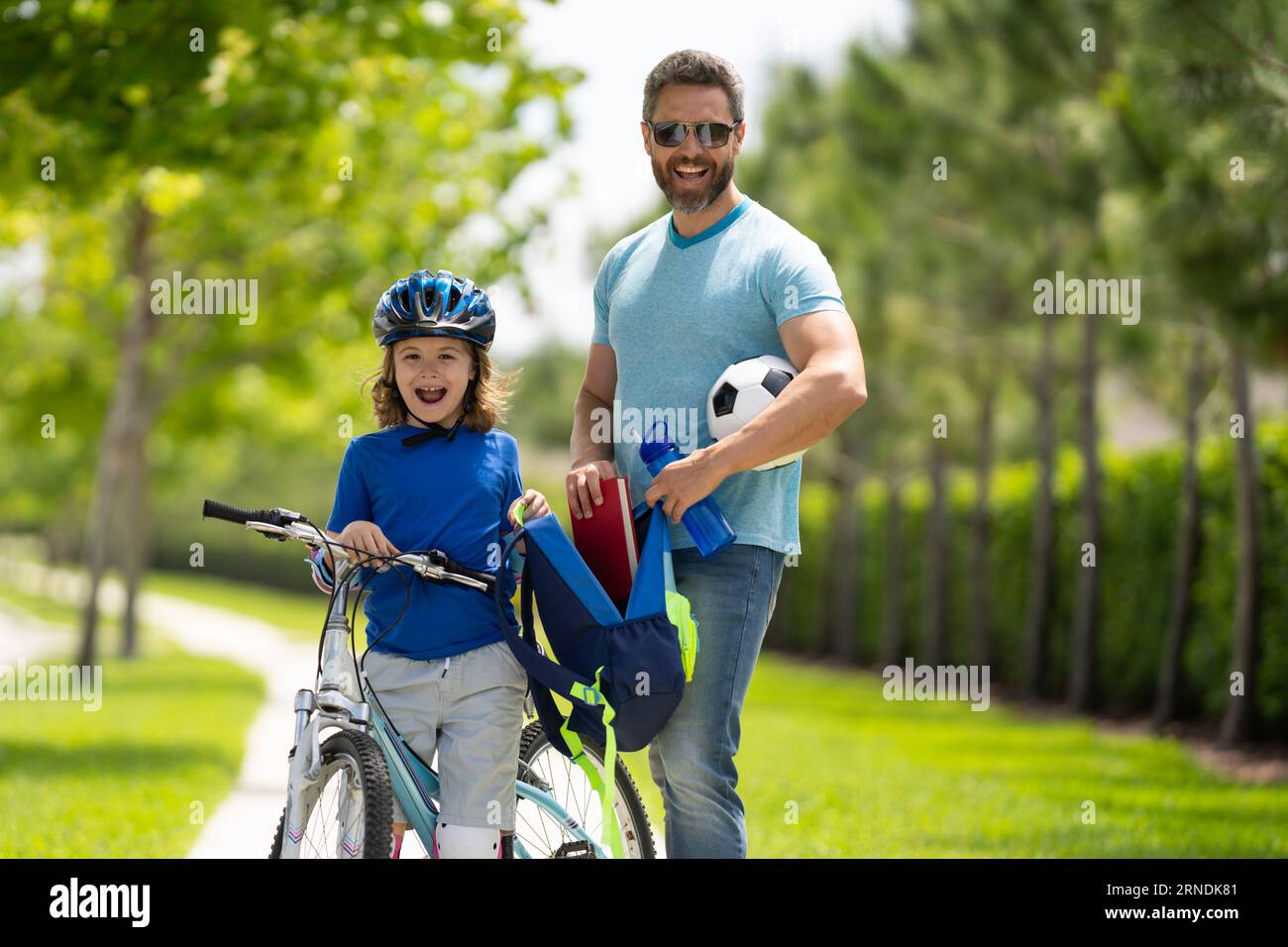 Father helping son get ready for school. Father and son ride a bicycle ...