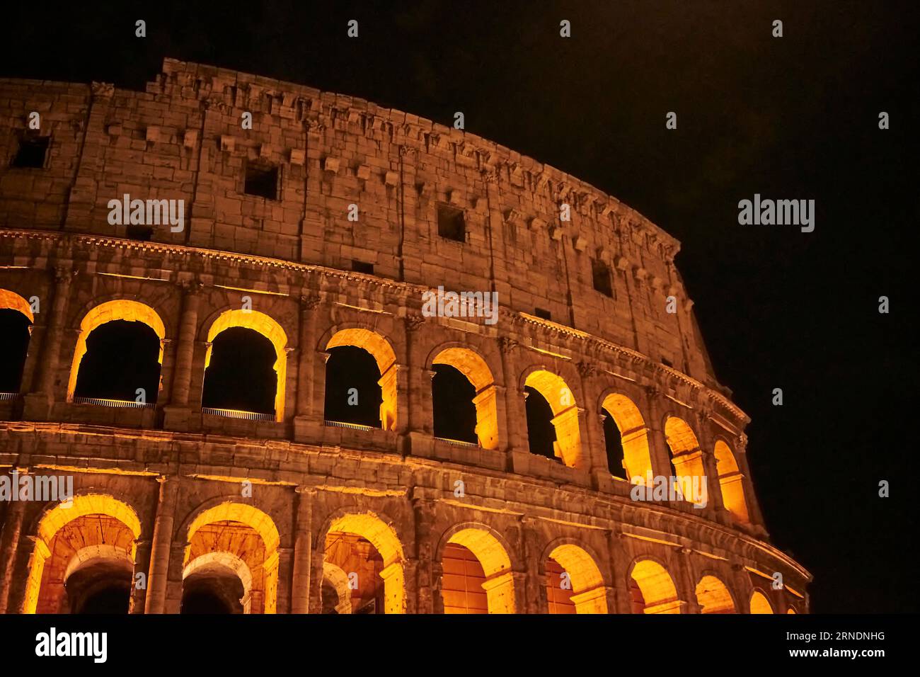 The Colosseum in Rome illuminated with bright lights during the night ...