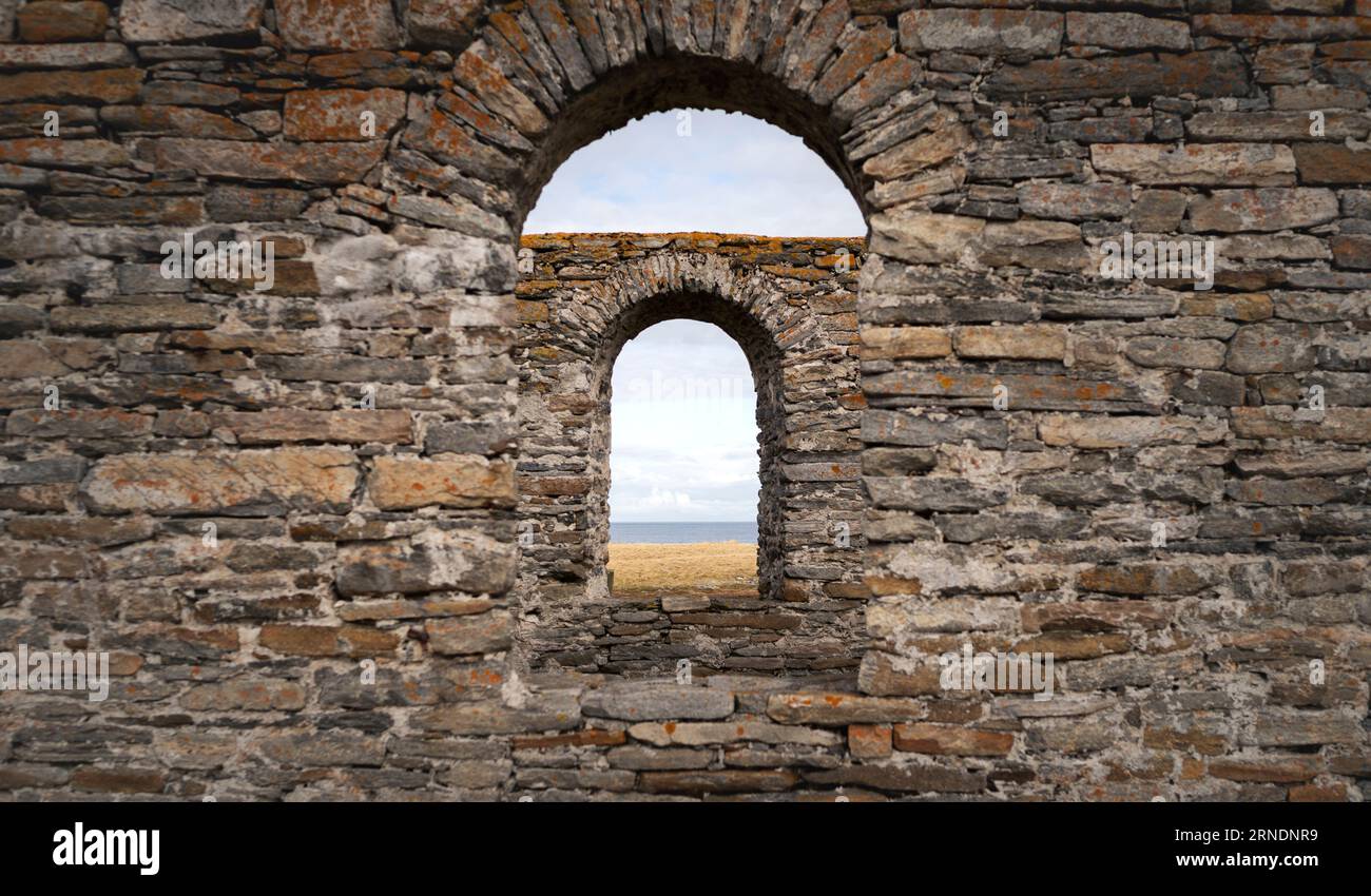 An arched window with a large ornamental stone centerpiece, illuminated ...