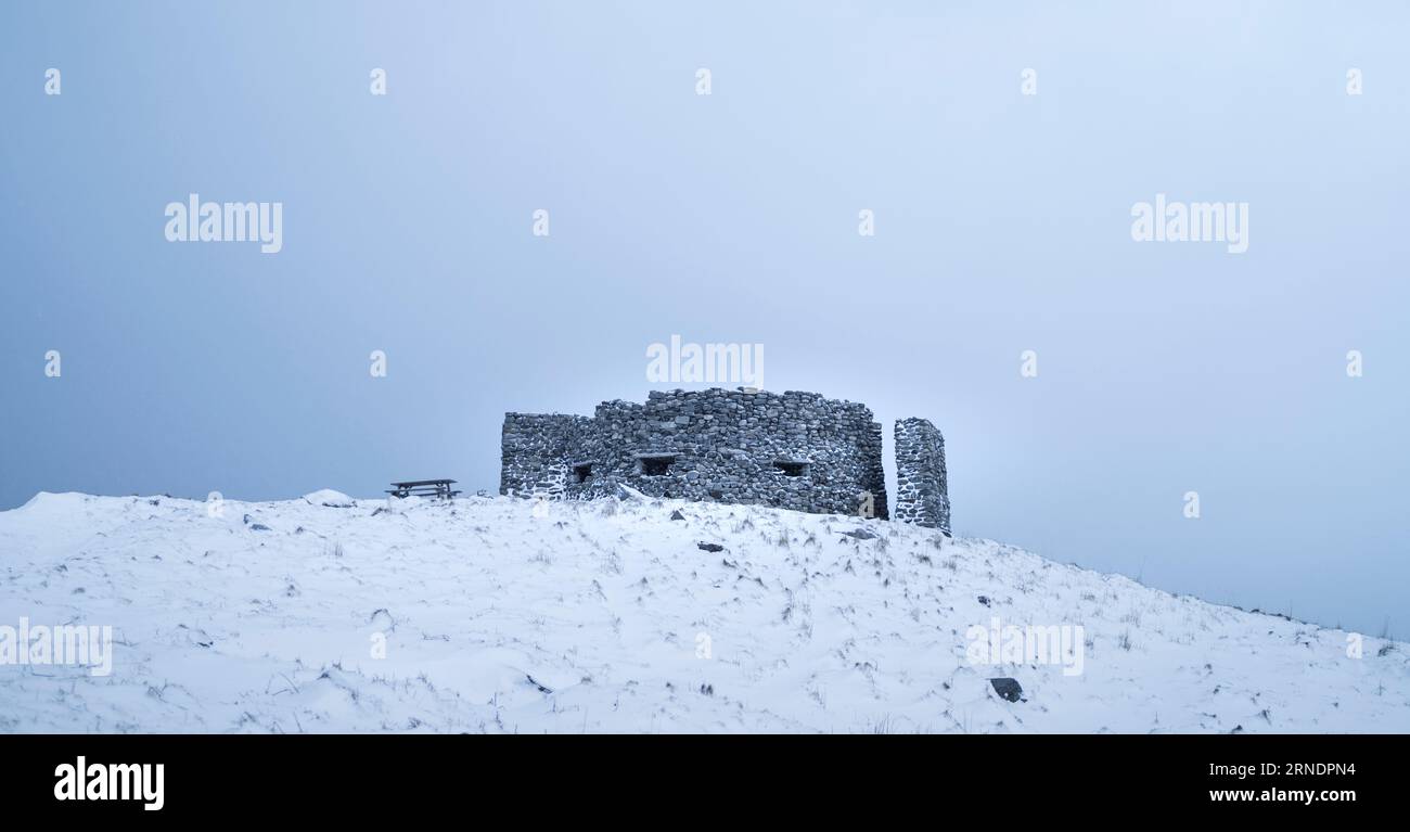 A majestic snow-covered hilltop with an ancient stone tower in the far ...