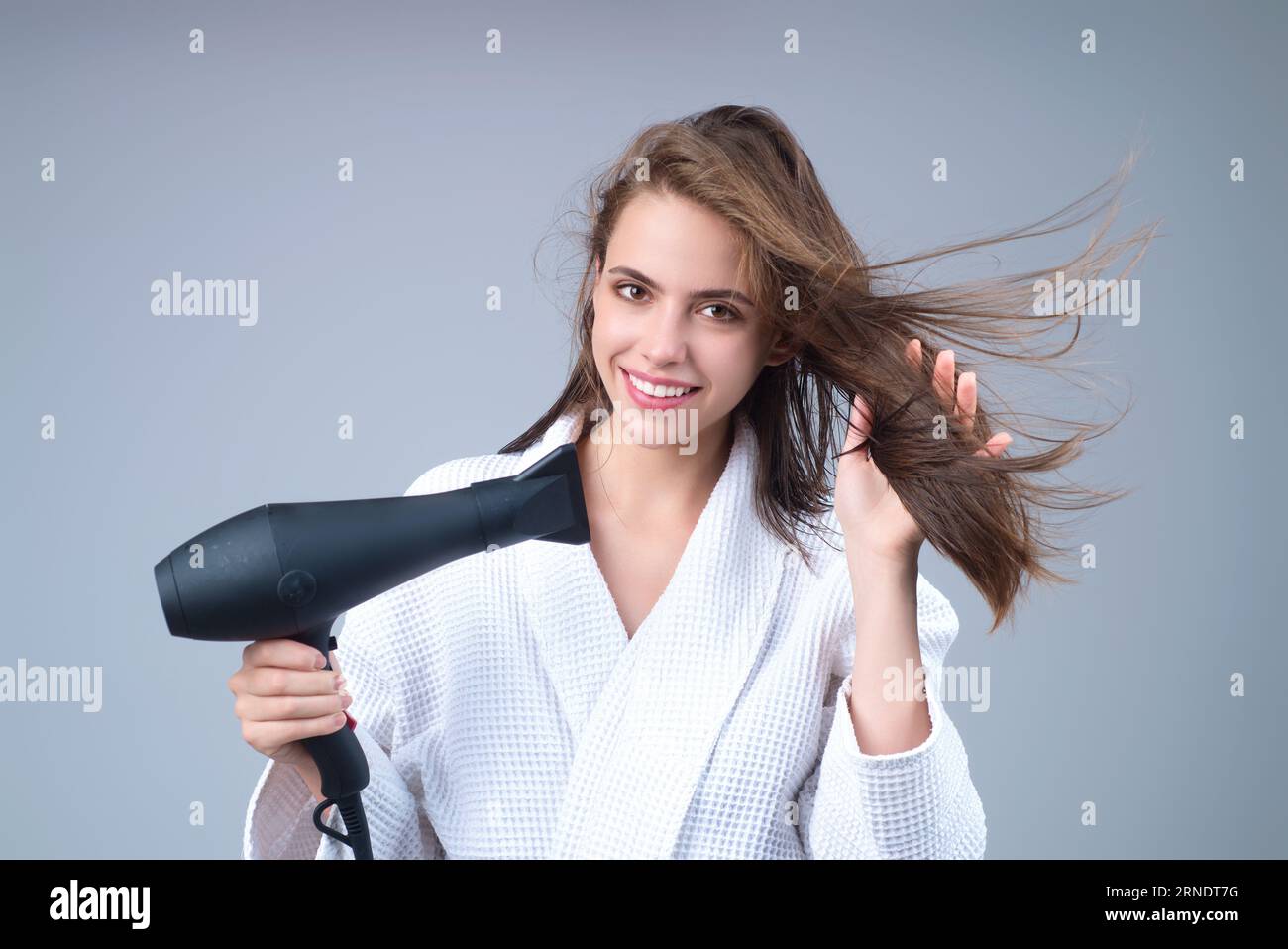 Woman with hairdryer isolated on studio background. Girl hold hairdryer ...