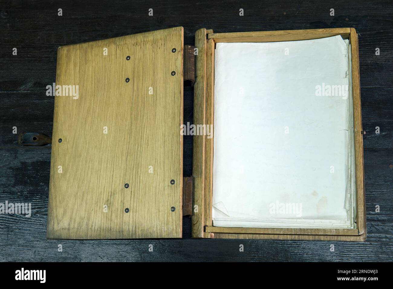 old log book in a wooden case with clasps on a black tabletop, open ...