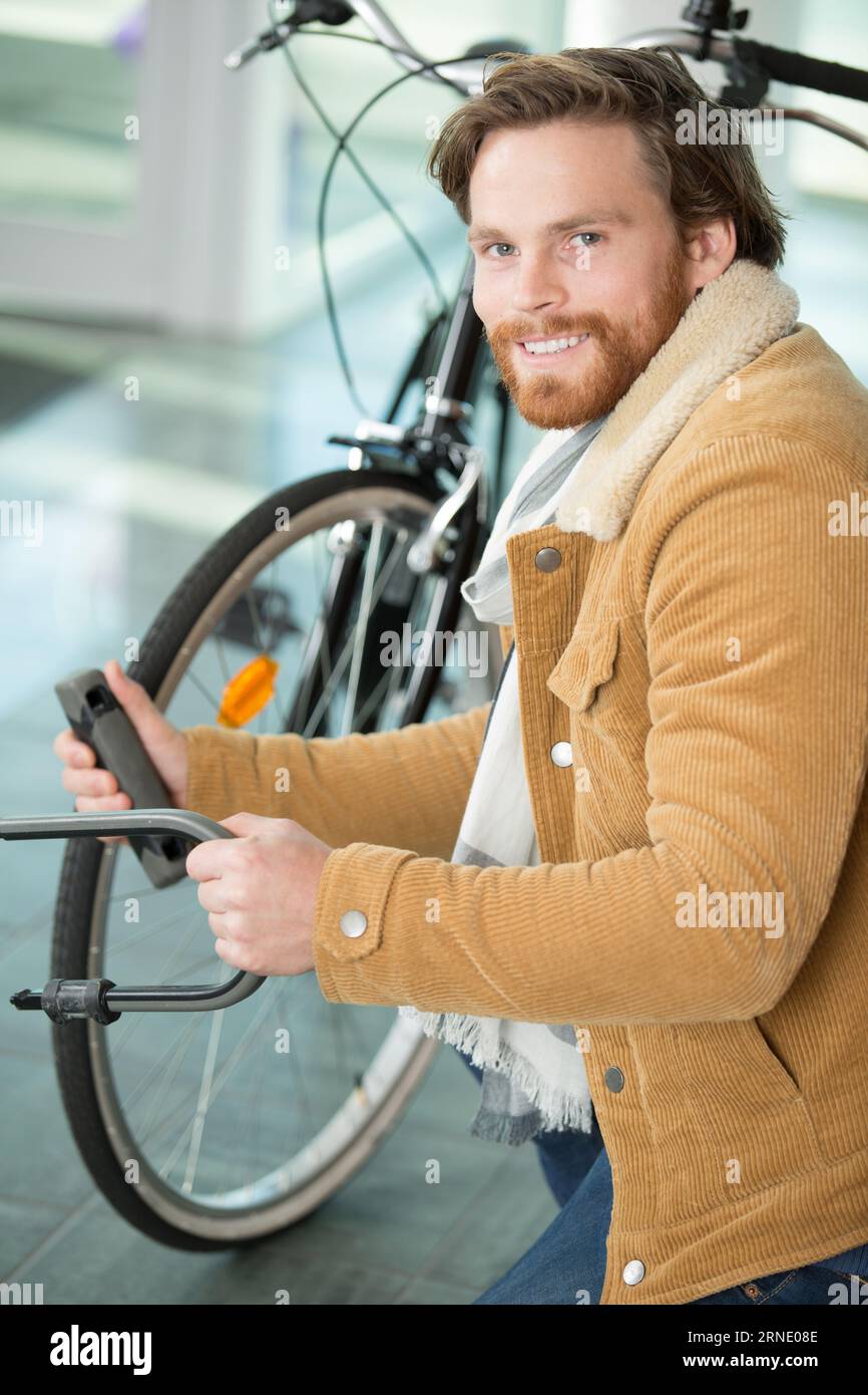 Man locking bicycle hi-res stock photography and images - Alamy