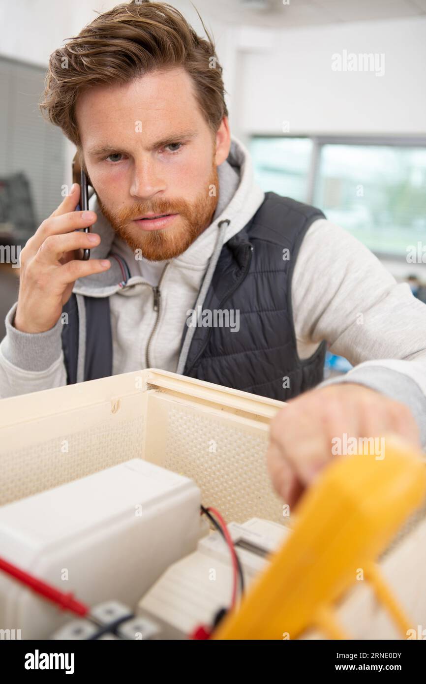 young technician using multimeter on electrical appliance Stock Photo ...