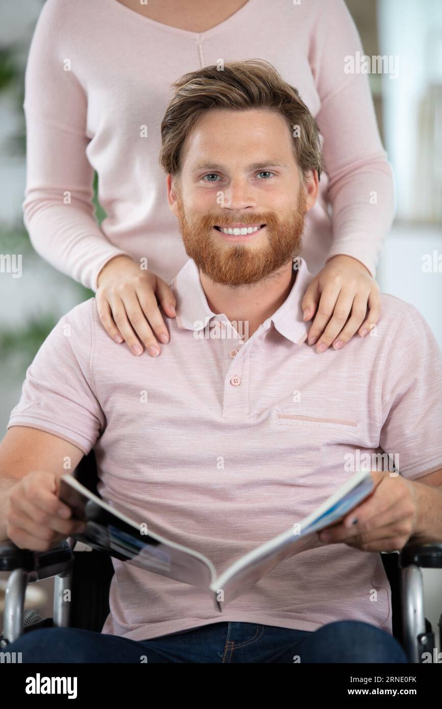 woman standing behind the back of her smiling disabled boyfriend Stock ...