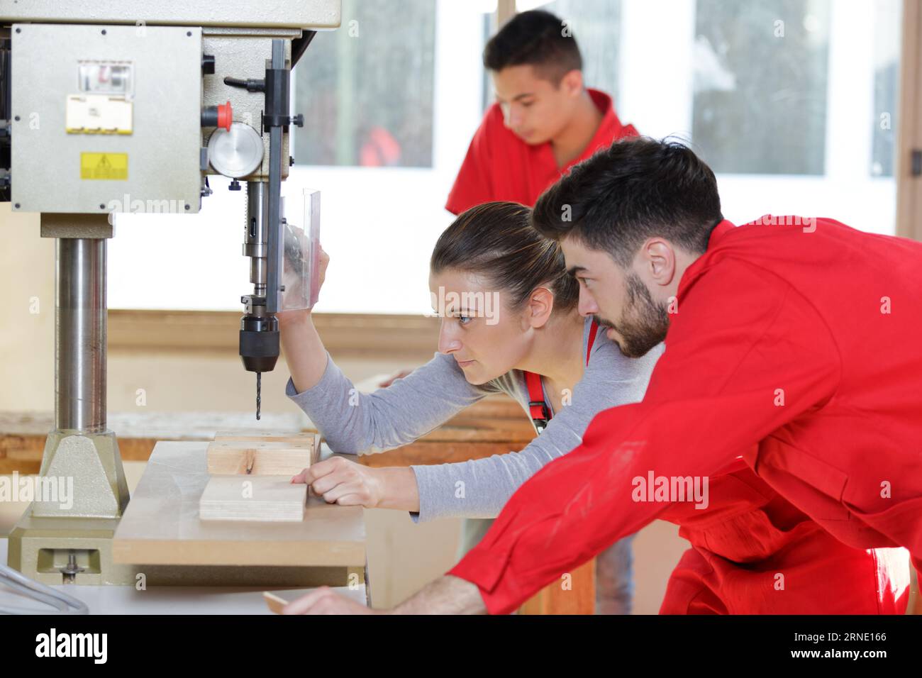 female apprentice drilling block for practice Stock Photo - Alamy