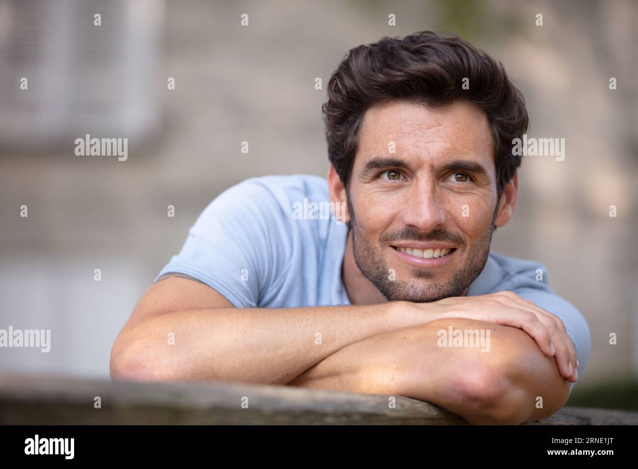 contented handsome man leaning on a fence Stock Photo - Alamy