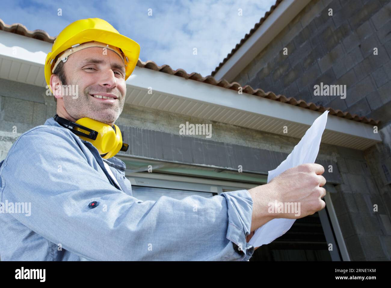 a builder checking plan outdoors Stock Photo - Alamy