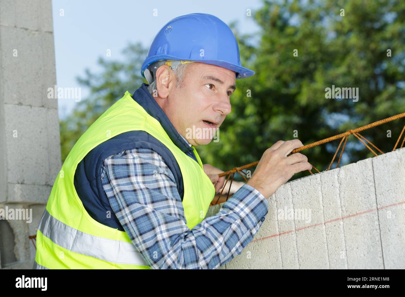 builder with spirit level on construction site wall Stock Photo - Alamy
