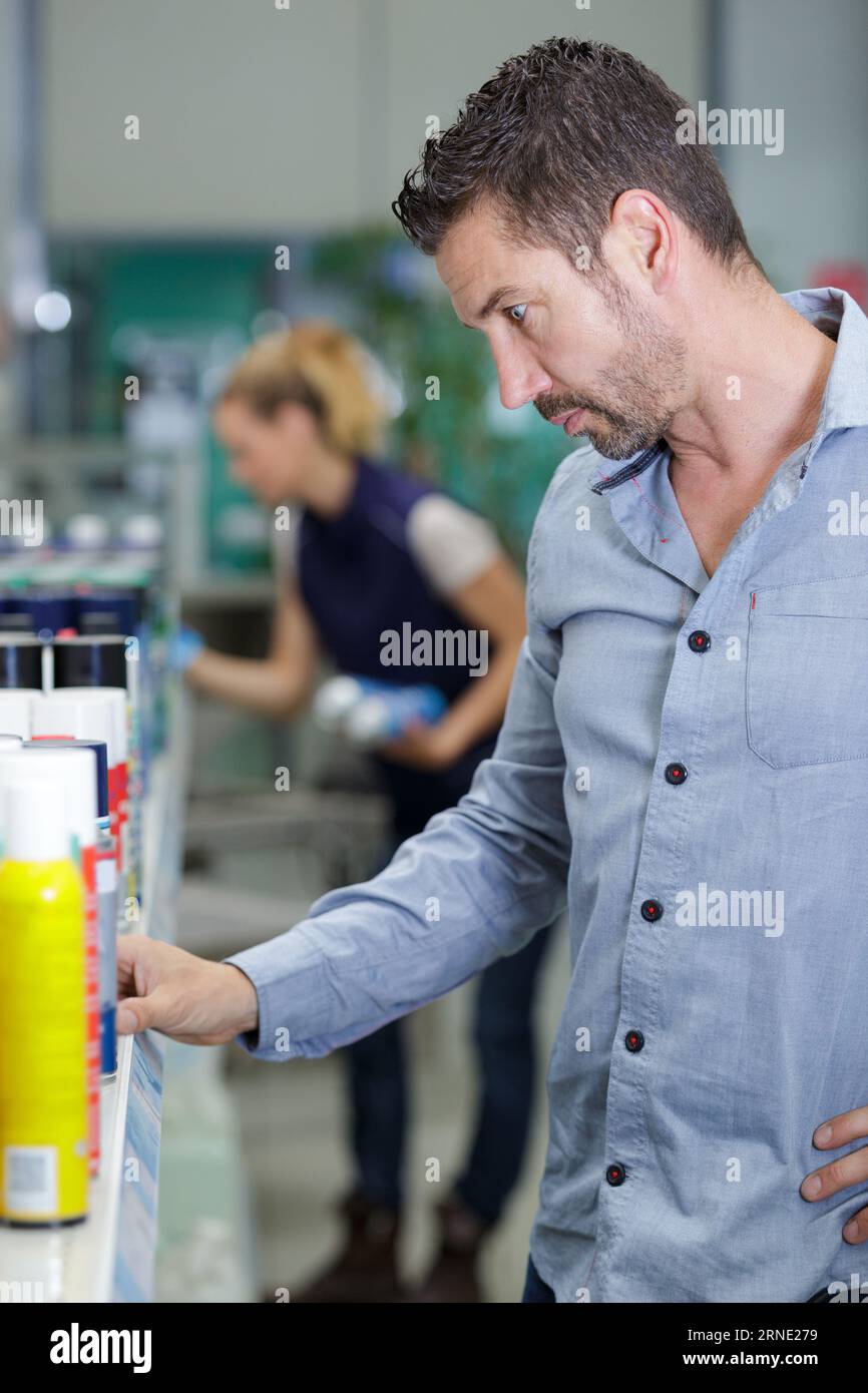 portrait of customer buying spray in shopping mall Stock Photo - Alamy