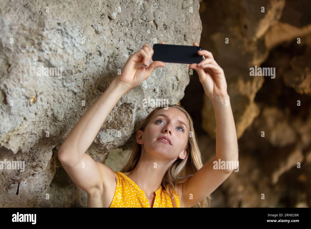 woman is taking a photo inside a cave Stock Photo - Alamy
