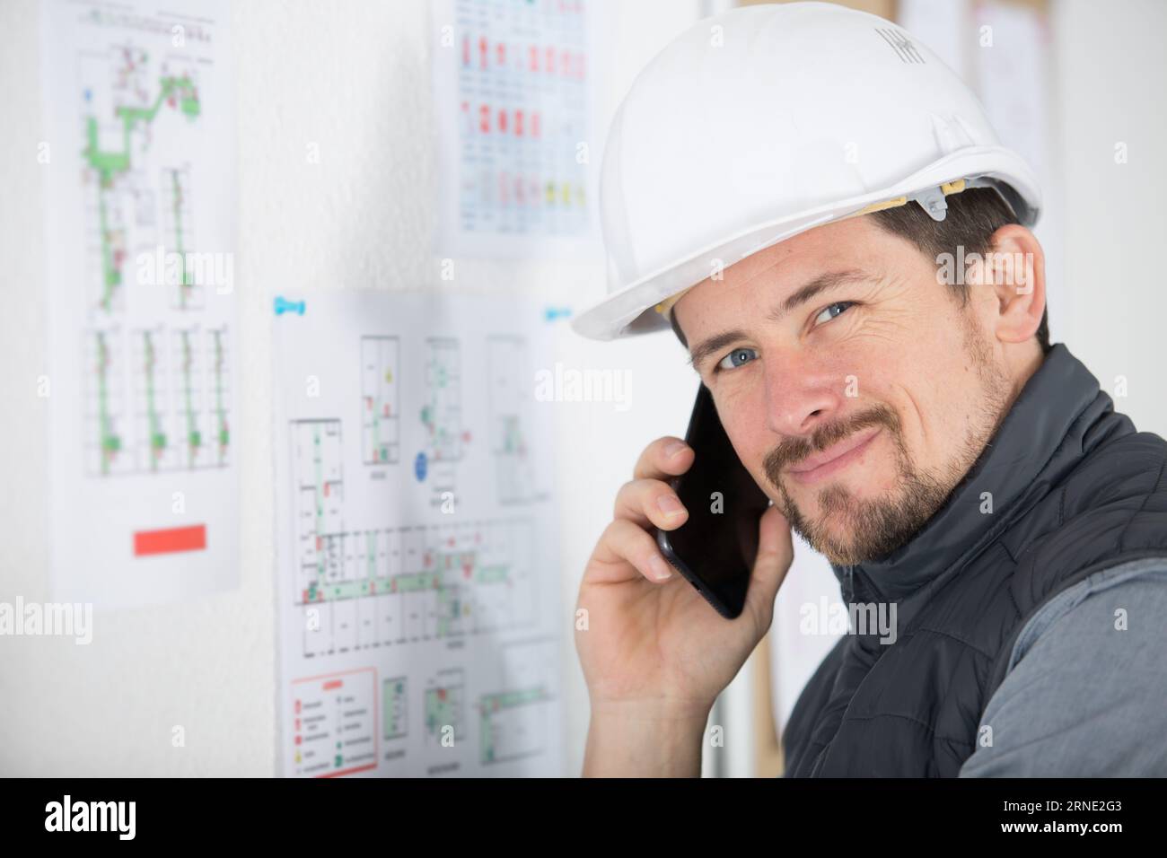 professional construction worker checking a project and calling Stock Photo - Alamy