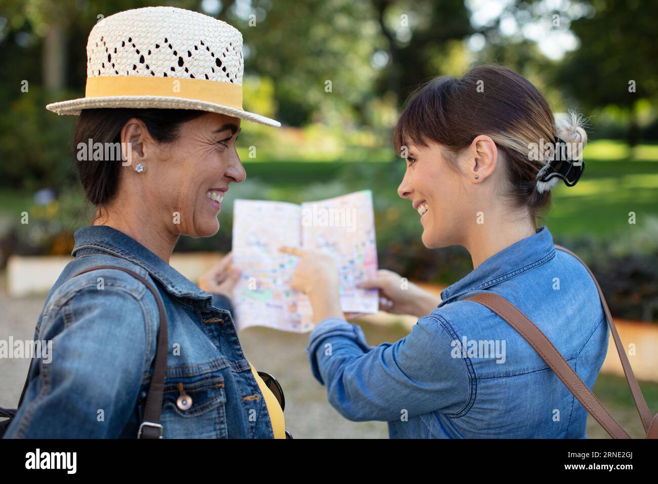 two girl womenusing a map in the city Stock Photo - Alamy