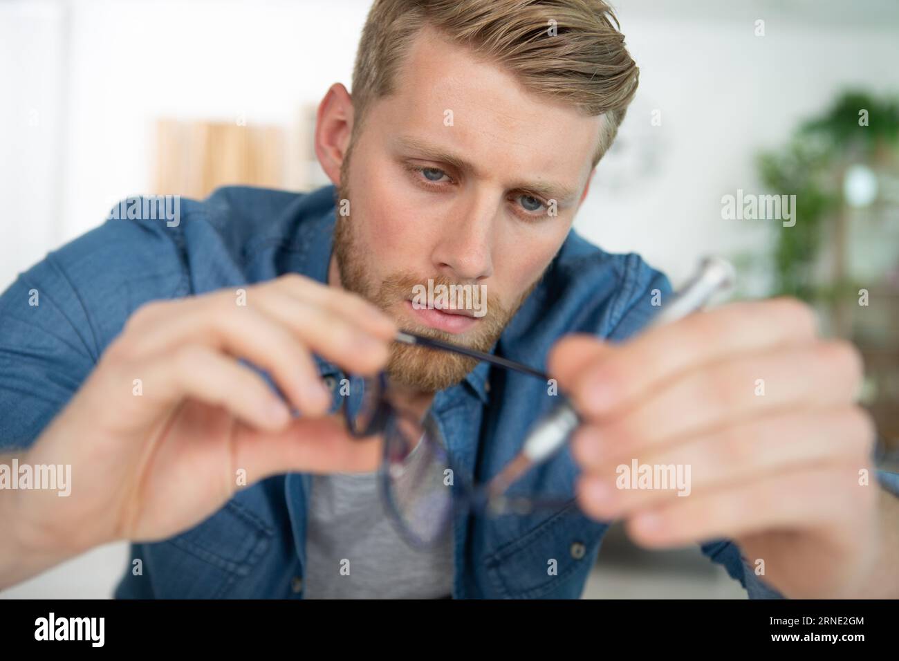 man fixing glasses with bending pliers Stock Photo - Alamy