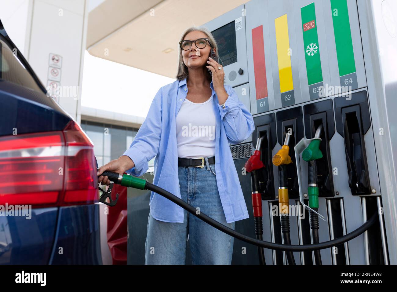 mature old woman refuels the car with a gas gun Stock Photo - Alamy