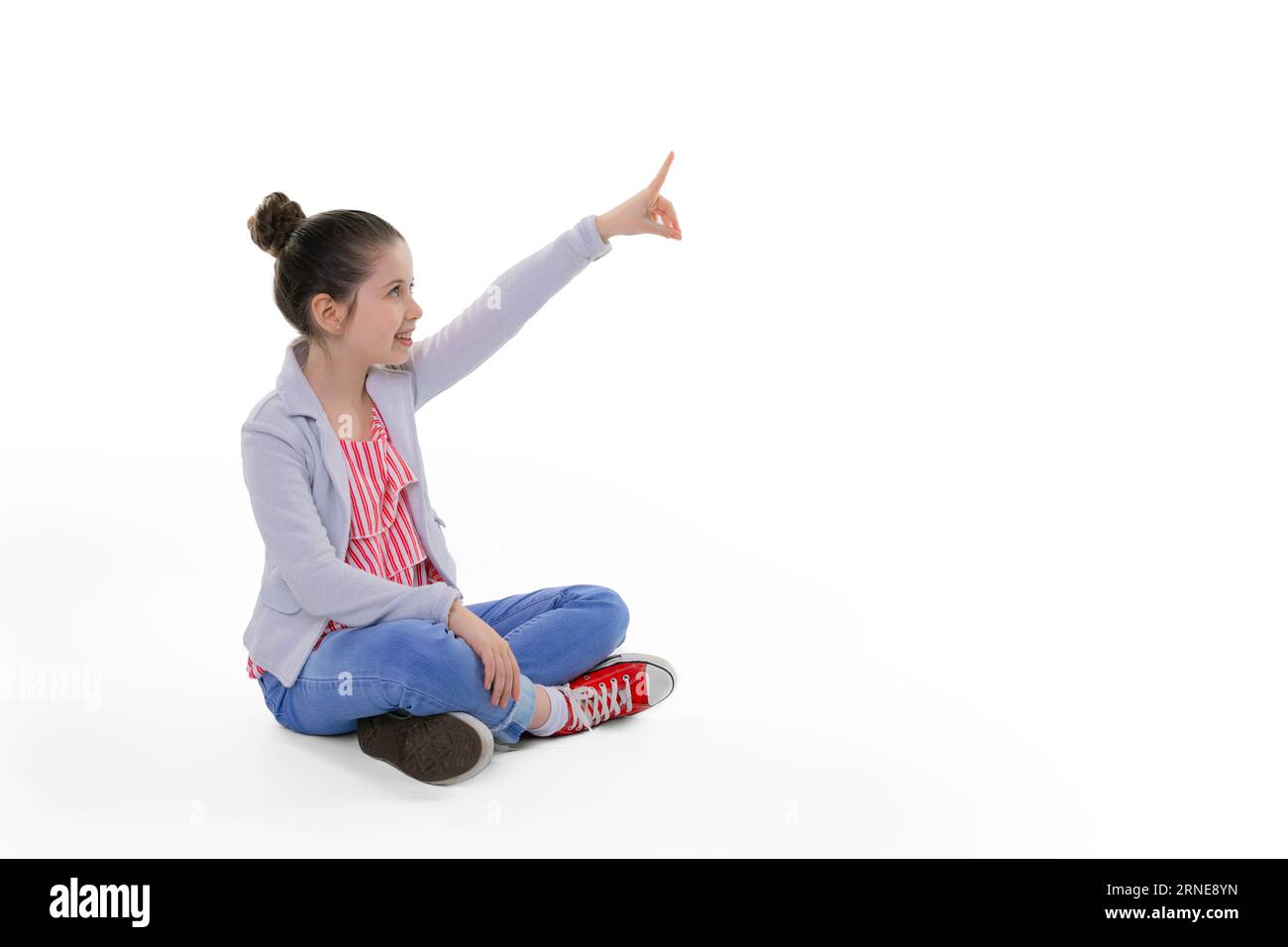 young childish girl point in the upper right corner to show with her ...