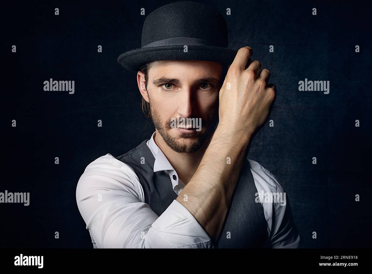 old vintage styled portrait of serious englishman with hand at hat look ...