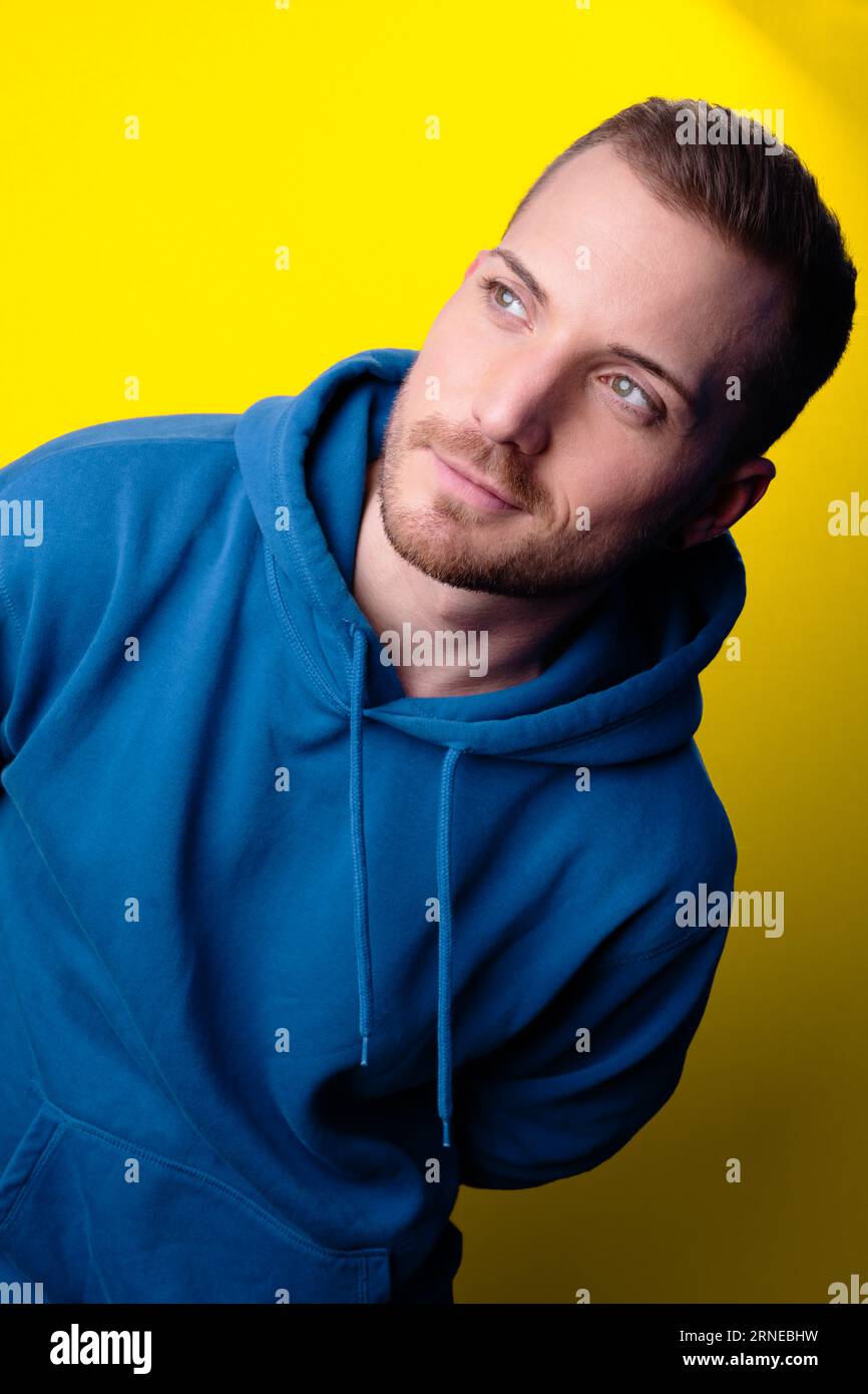 Handsome joyful male model look to side while lean over with his top ...