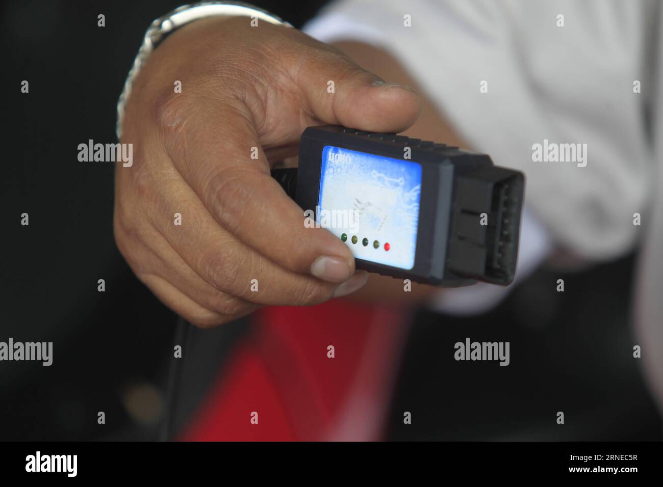 An employee holds a device in a vehicular inspection center equipped to ...