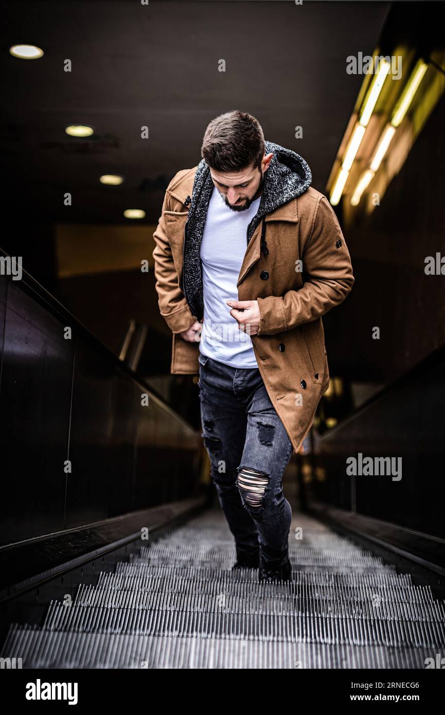 man walk slow on steps up from underground to city while stand on ...