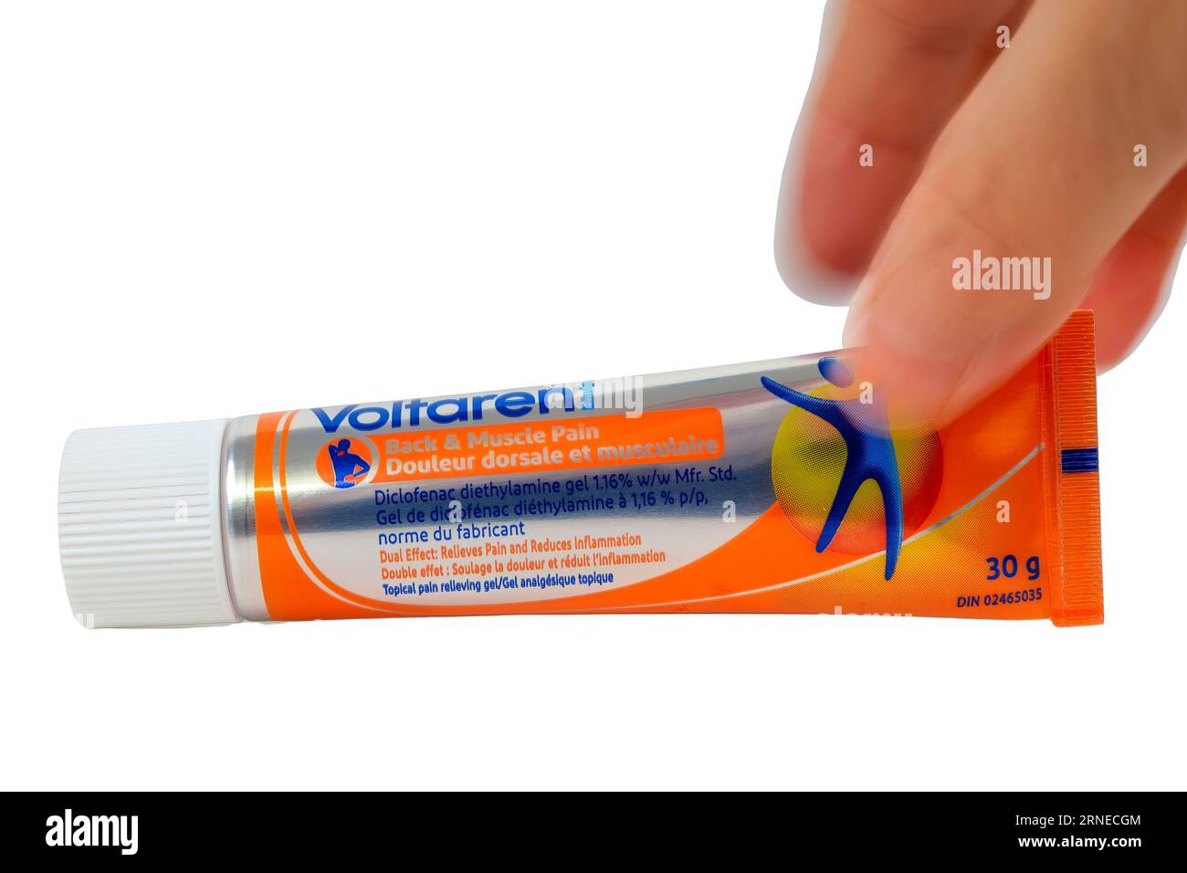 Hand of a woman grabbing a container of Voltaren pain relief cream ...