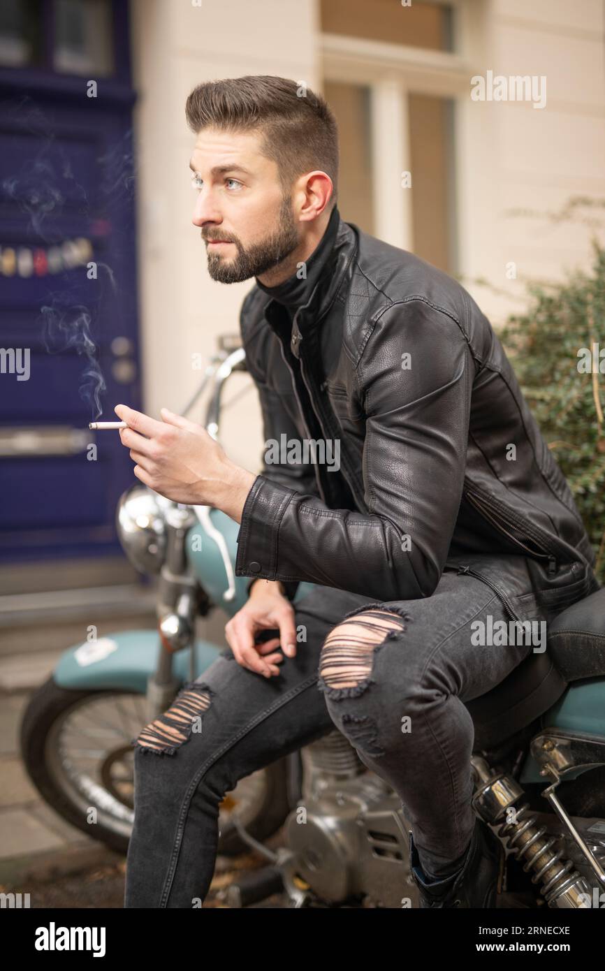 smoking handsome macho motorcyclist sit on chopper while being hot and ...