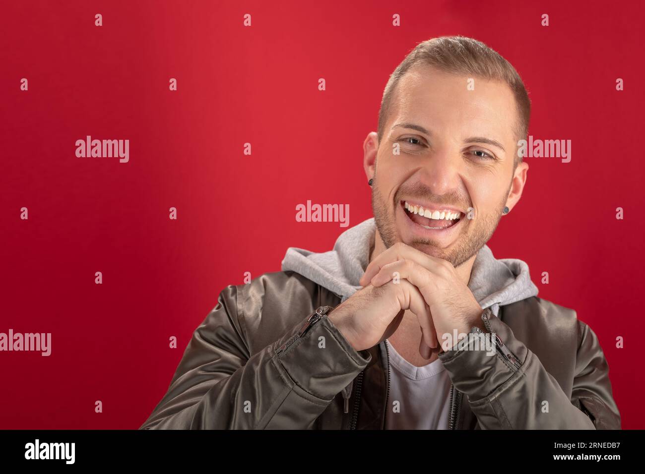 handsome man laugh out loud with open mouth and hands on chin while ...