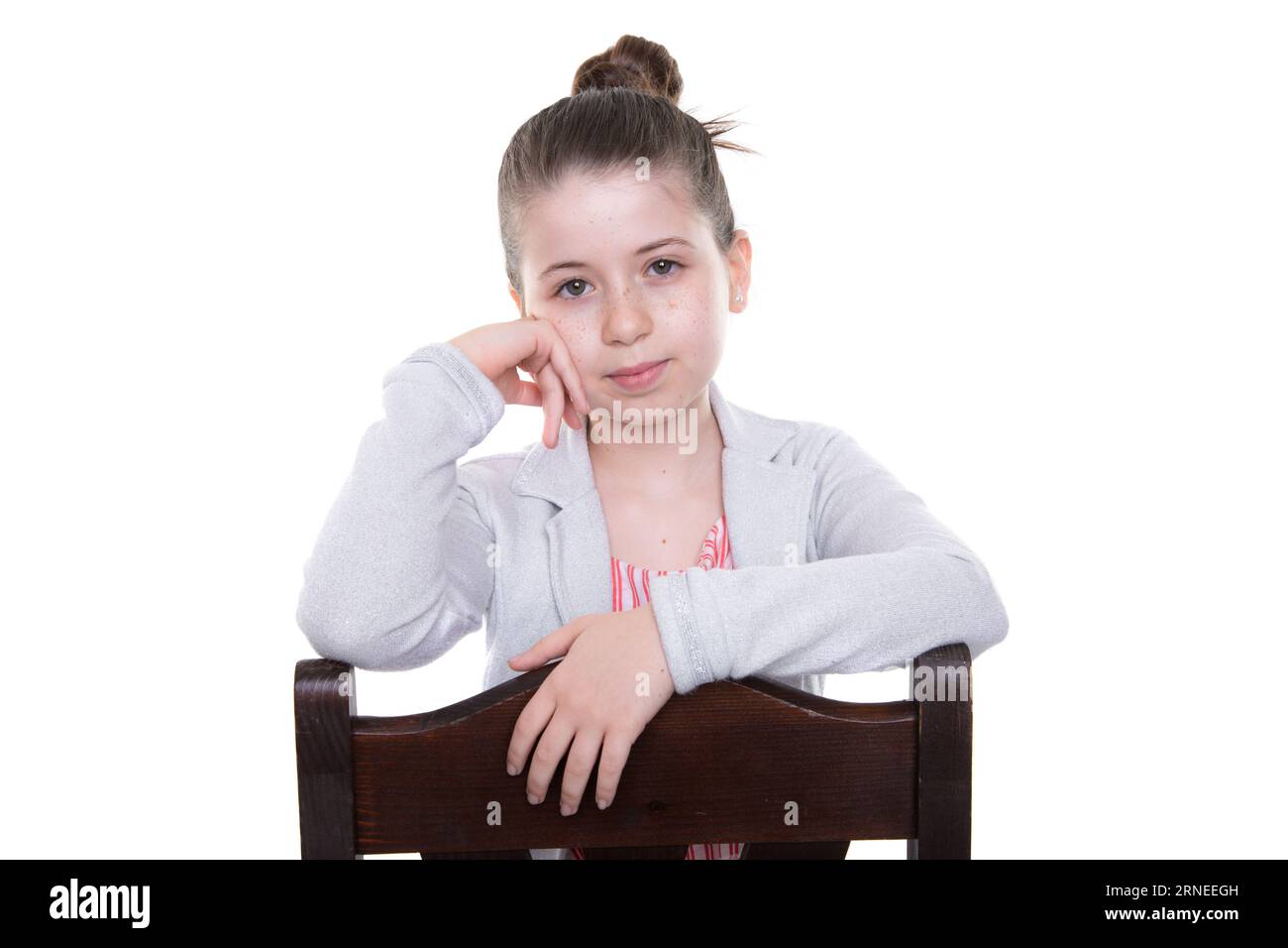 young child girl with hand at face look neutral and serious at camera ...