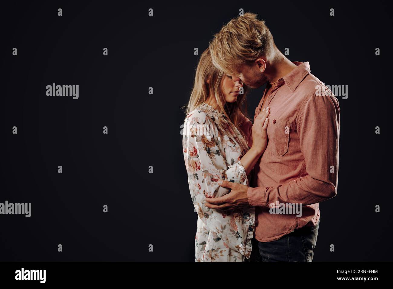Loving couple stand and hold tight, with their heads close together ...