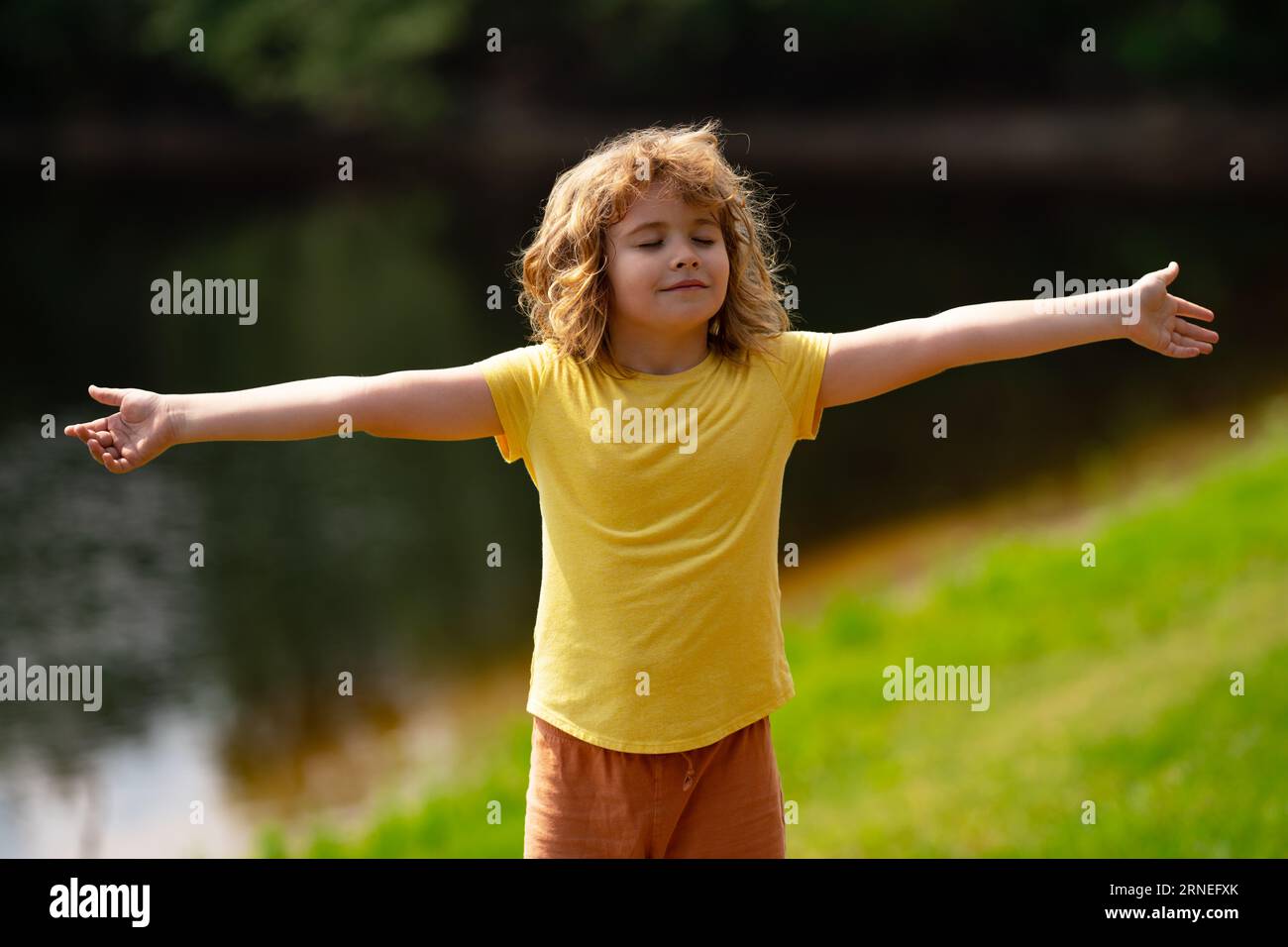Happy kid with arms up enjoying freedom in nature. Child open arms ...