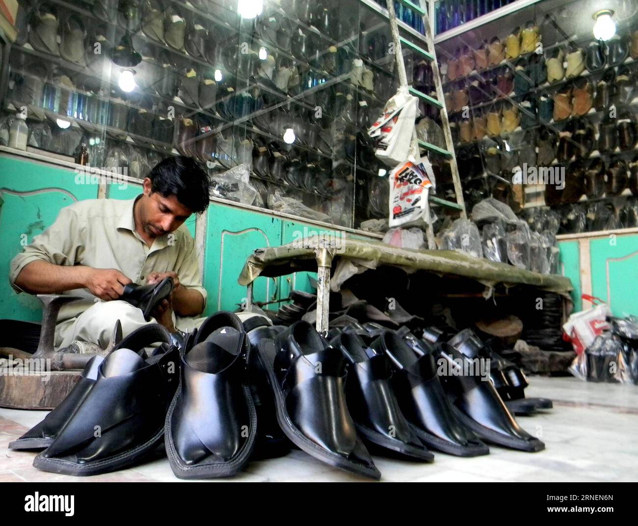 (160629) -- PESHAWAR, June 29, 2016 -- A worker makes traditional shoes ...