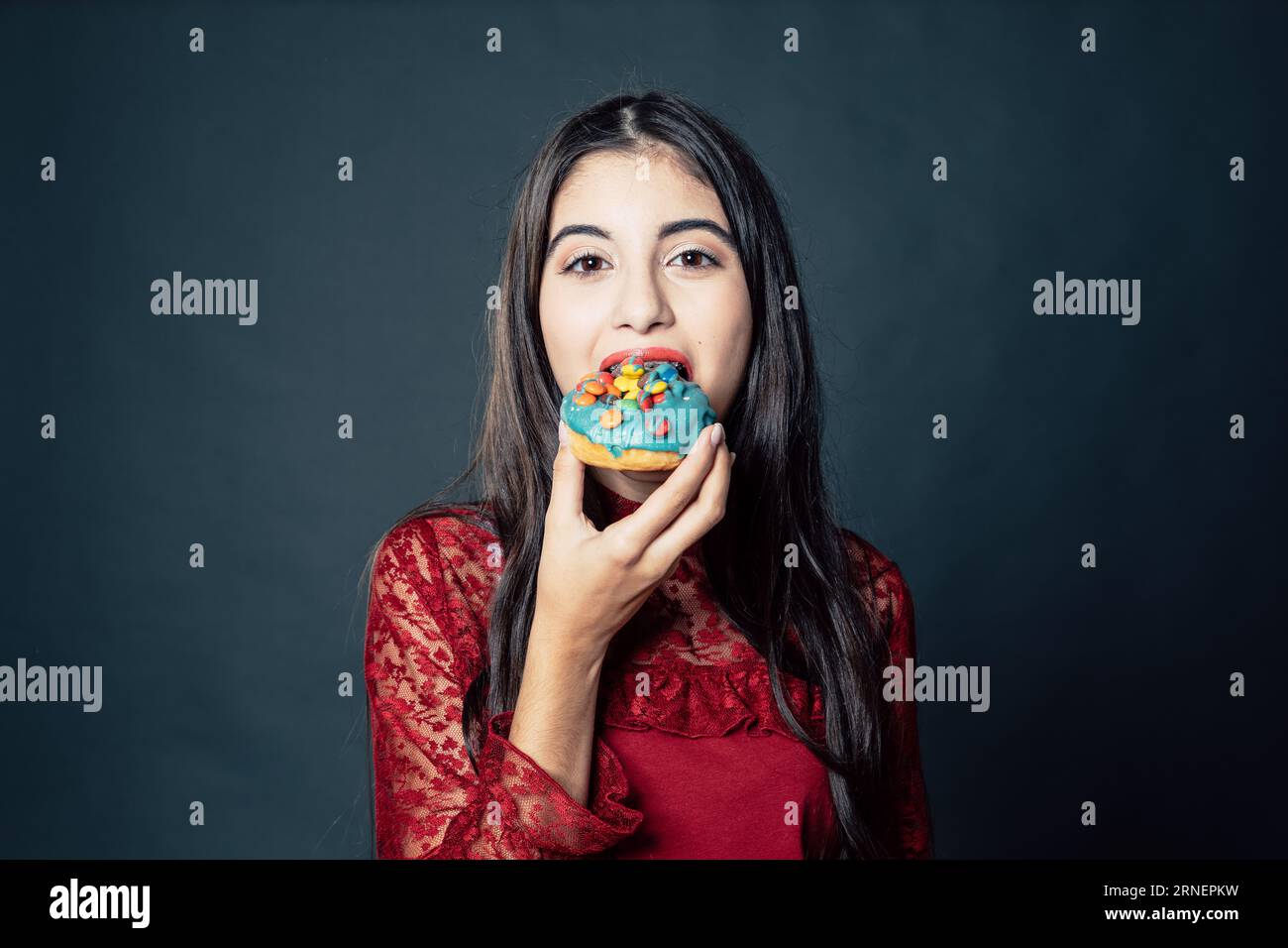 Girl biting in Donut and look in camera Stock Photo - Alamy