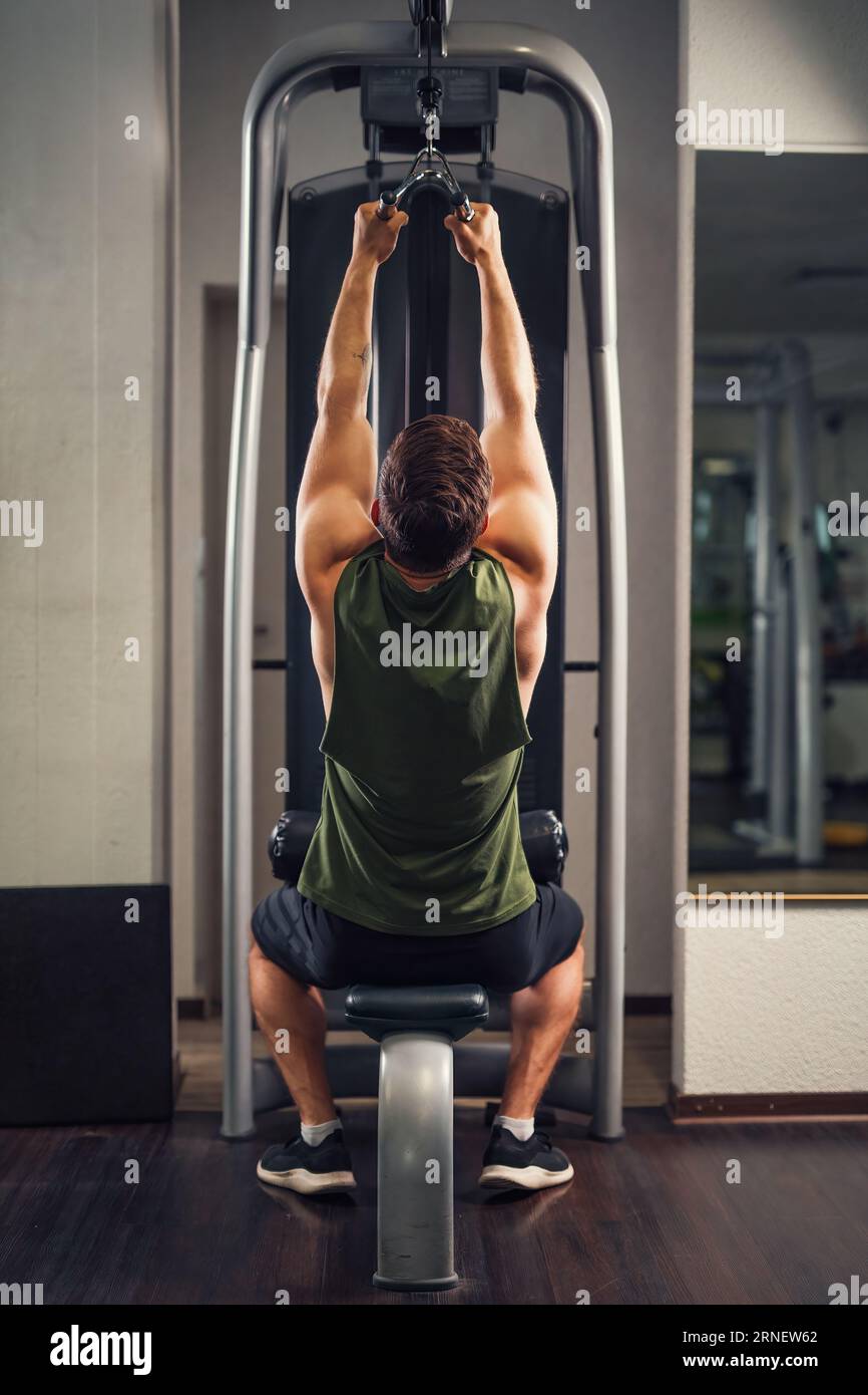 lat pull at multi lat machine wit v-form handle at gym Stock Photo - Alamy