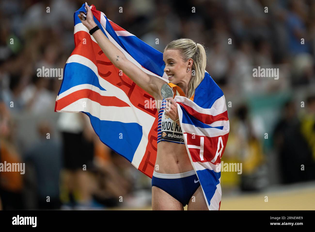 Keely Hodgkinson celebrating her medal with her country's flag in the ...