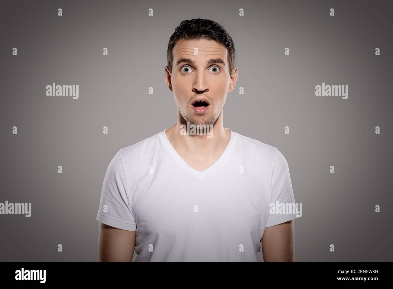 shocked man with eyes and mouth wide open is starring right into camera ...