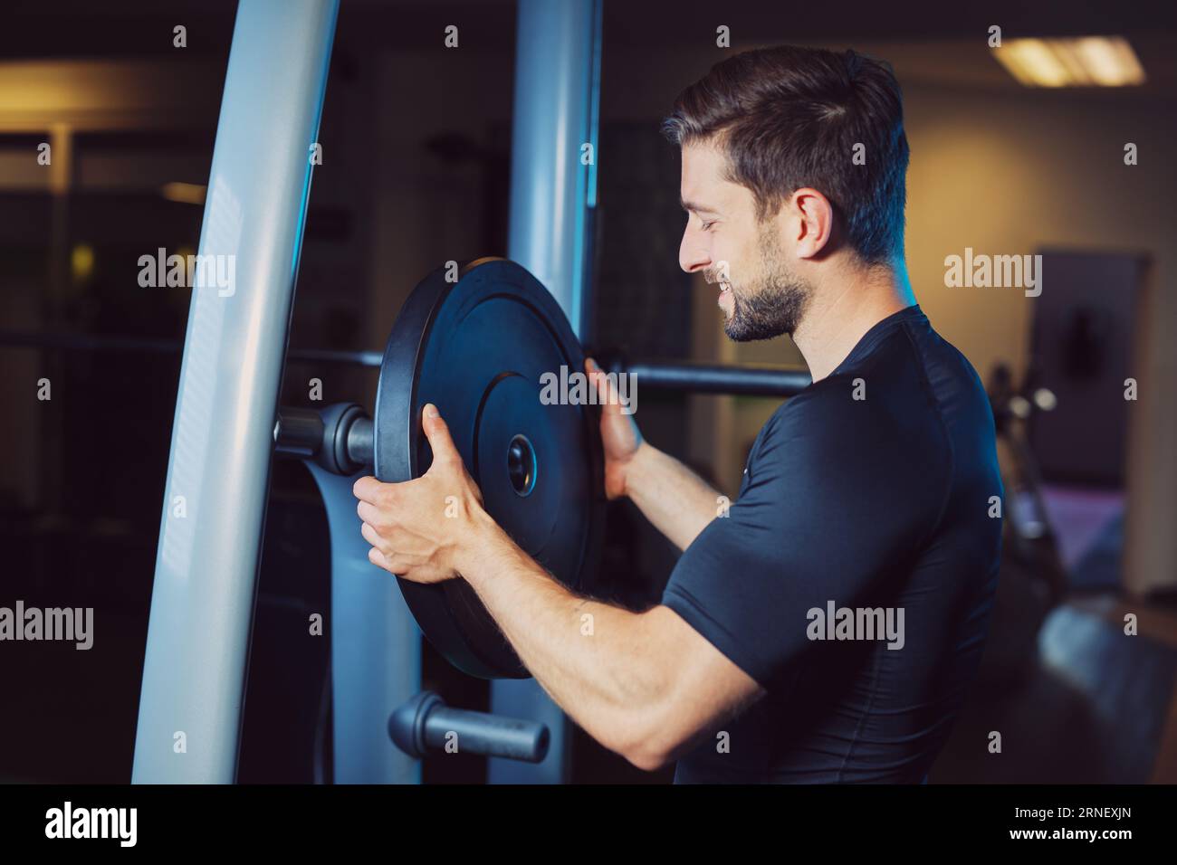 arrange weight discs at lifting machine at gym happily and satisfied ...