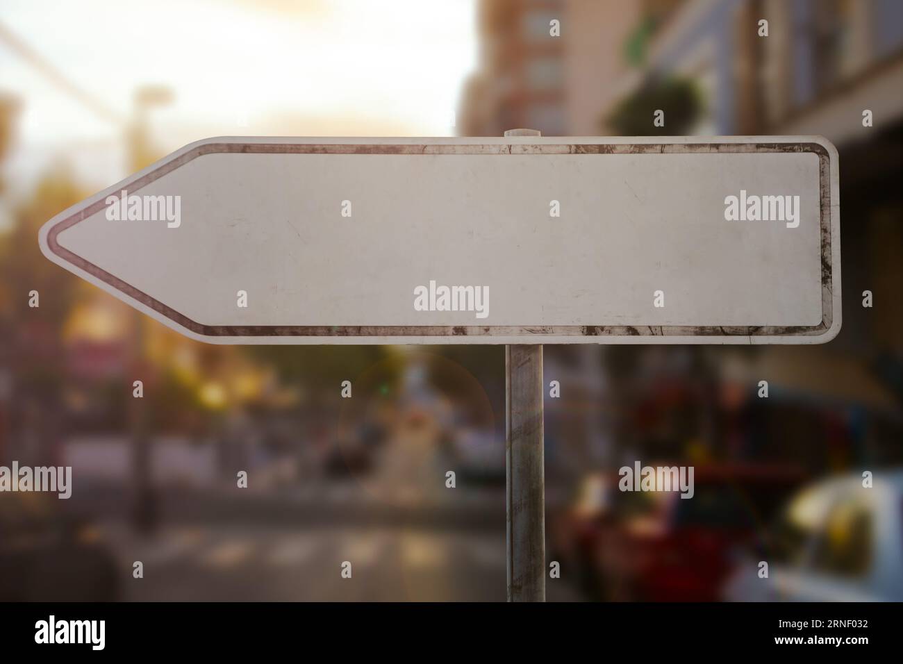 old rusty blank sign board with arrow to left stand in city while ...