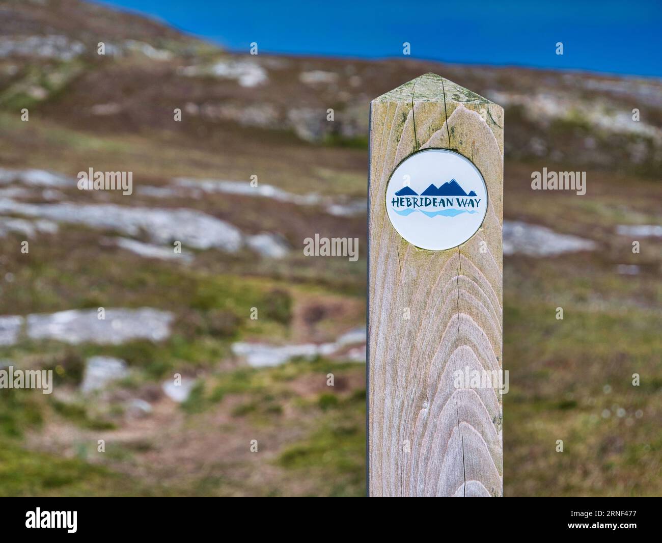 A white sign with blue print marks the route of the Hebridean Way ...