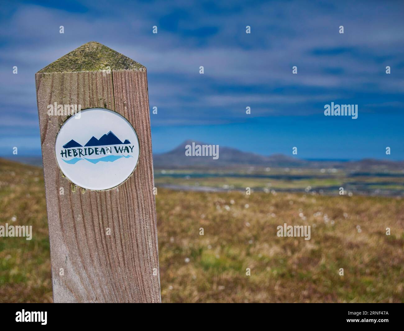A white sign with blue print marks the route of the Hebridean Way ...