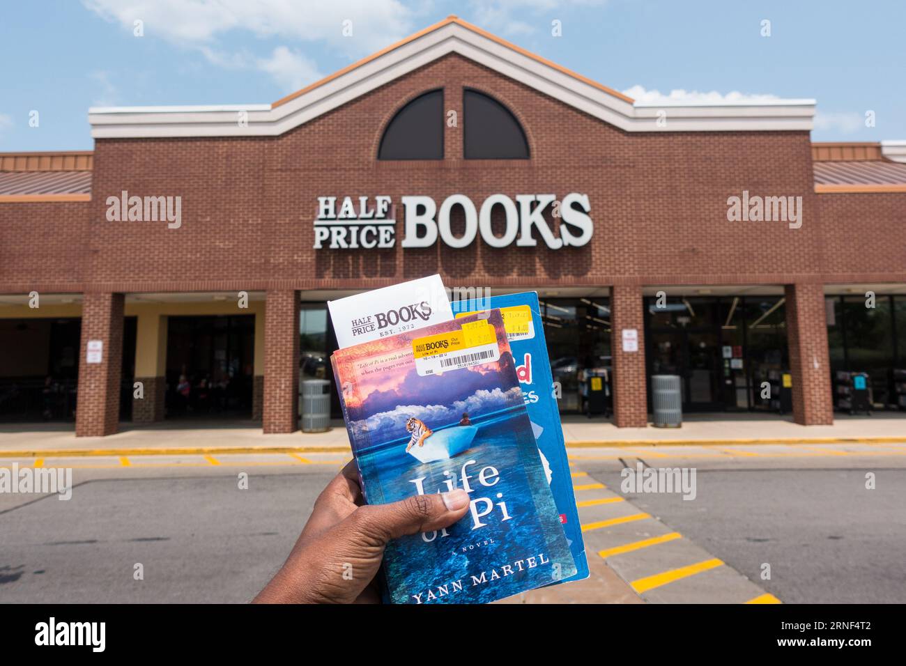 Man holding a book bought at Half price book store in Dayton, Ohio, USA ...