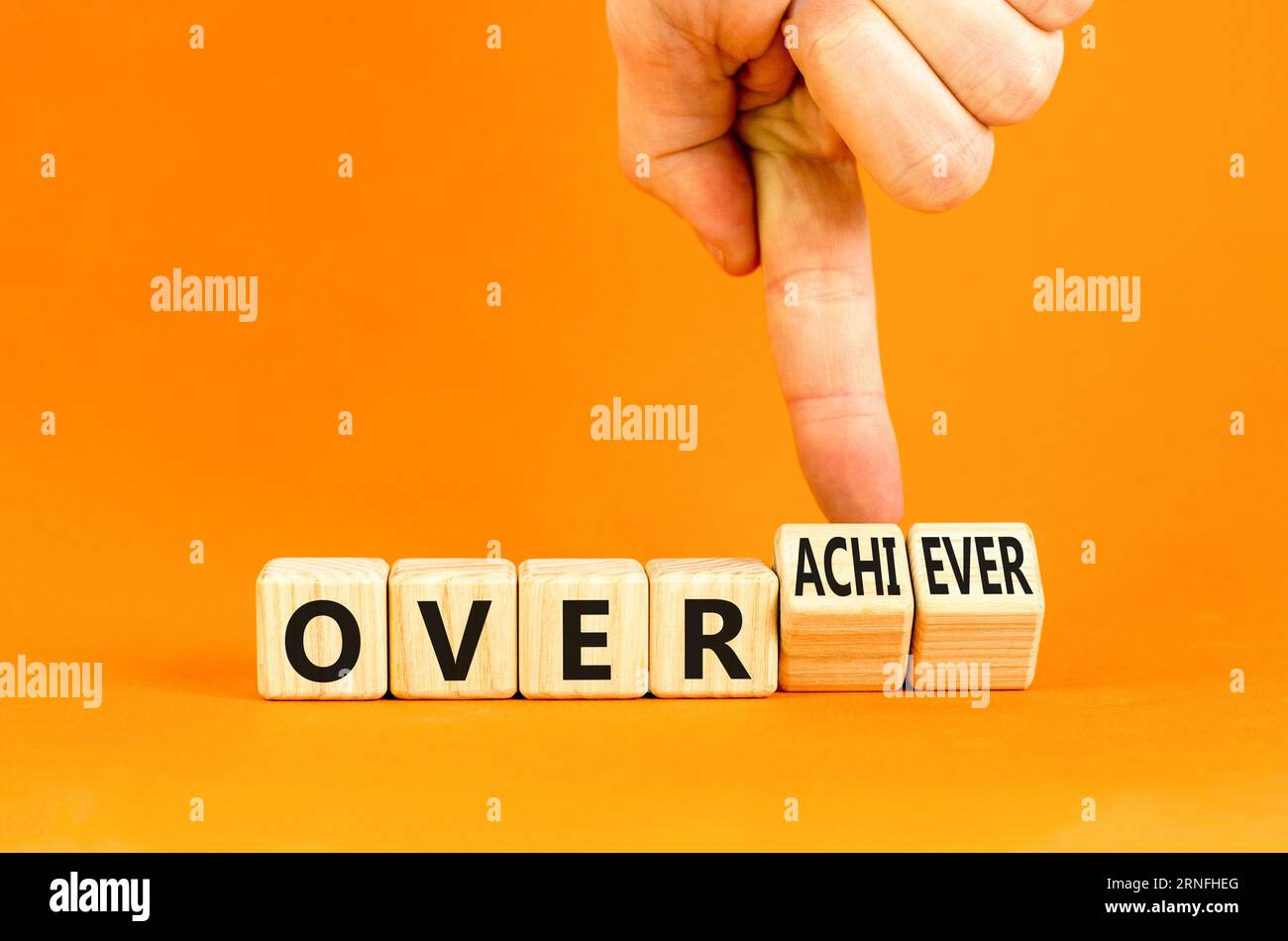 Achiever or overachiever symbol. Businessman turns wooden cubes and ...