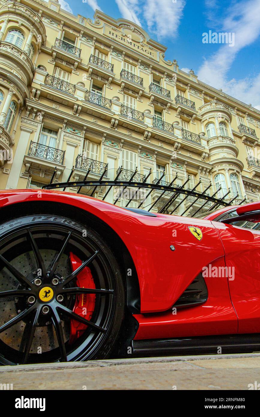 A red Ferrari with yellow prancing horse parked outside Hôtel Hermitage ...