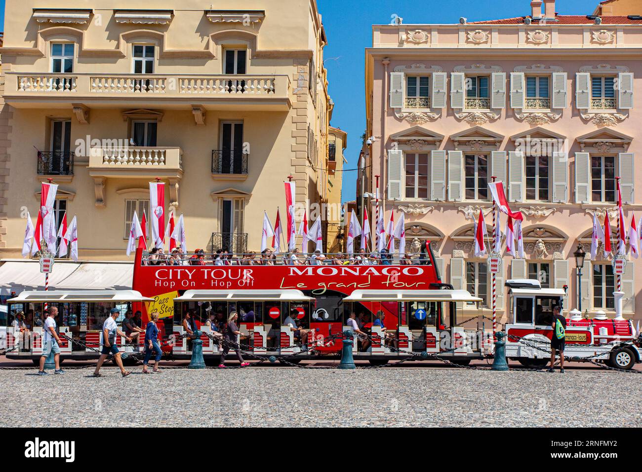Flags, a tourist train and city tour bus in Monaco old town Stock Photo ...