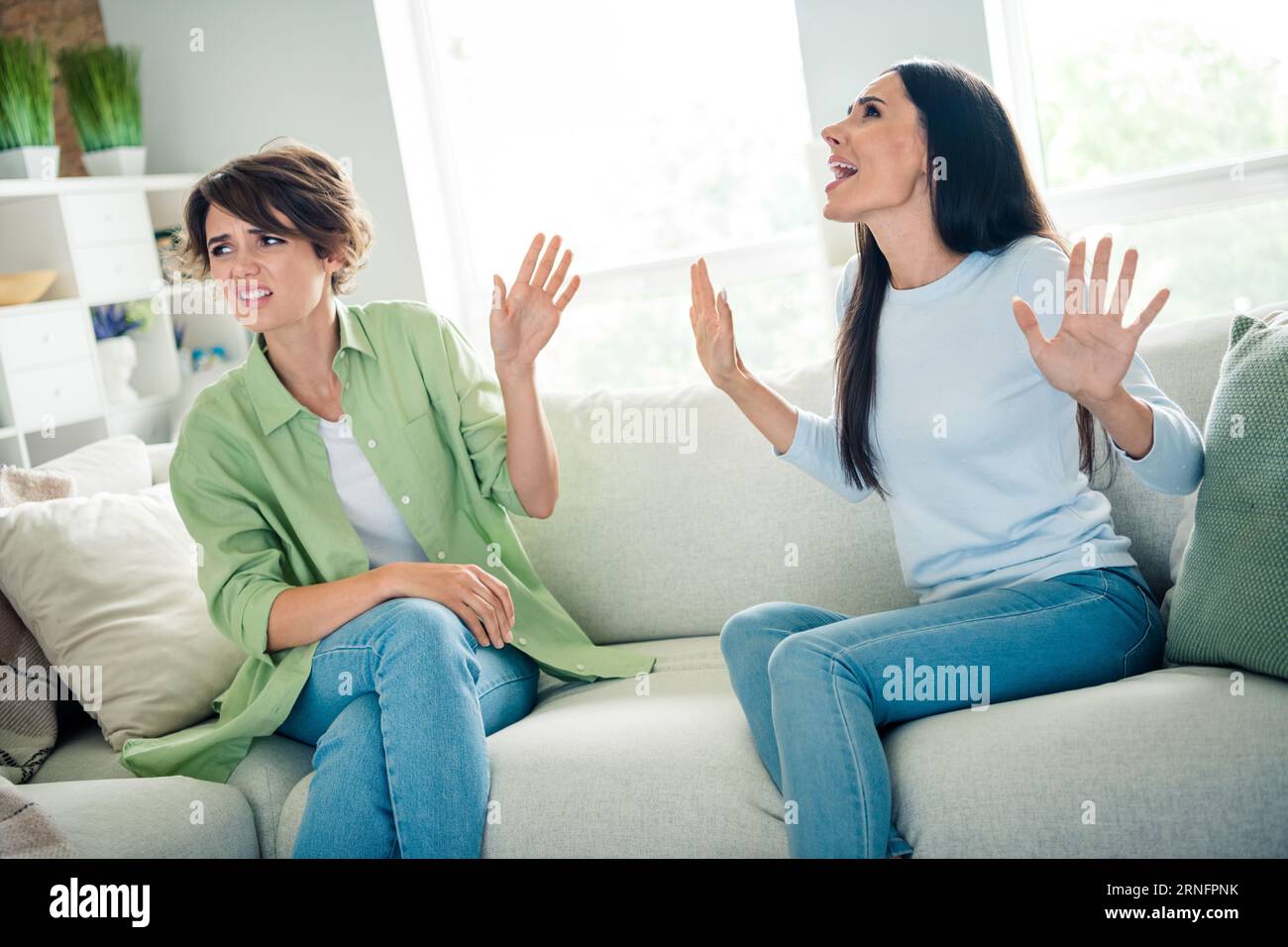 Photo of two unsatisfied angry people sitting couch yell ignore each ...